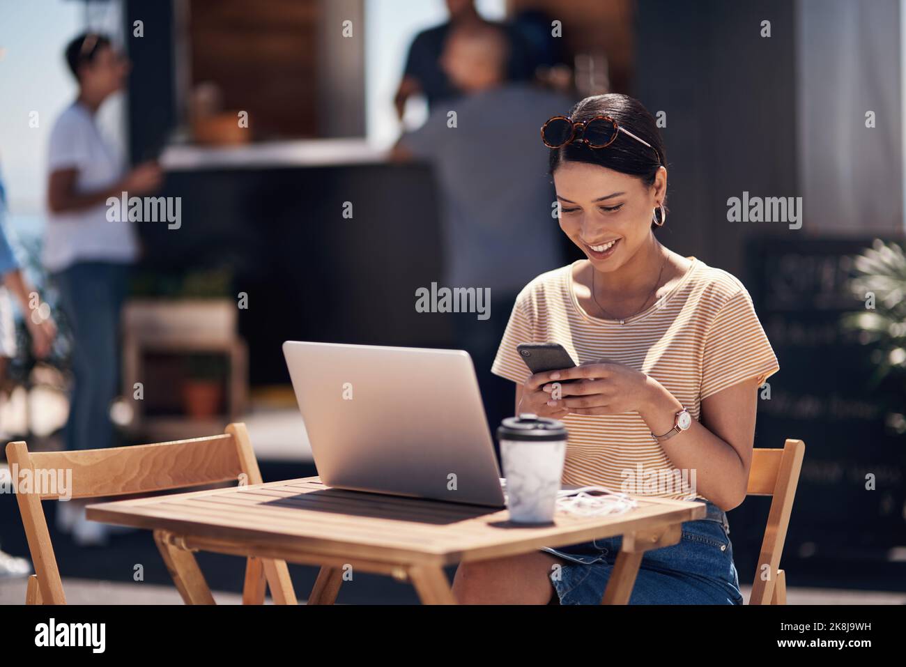 He knows how to make me laugh. a cheerful young woman texting on her cellphone while doing work ...