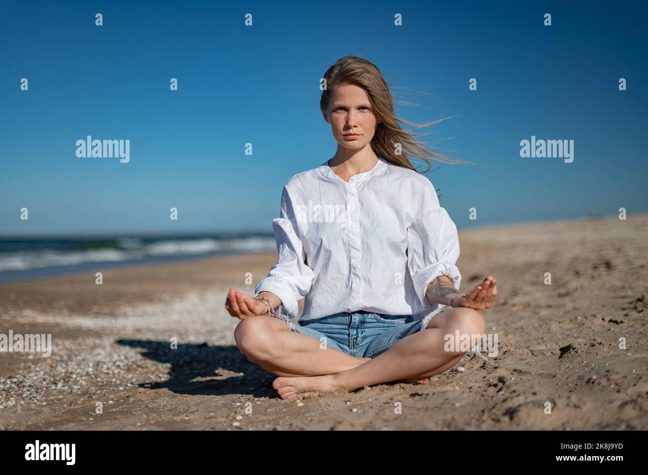 Girl practice meditation on the beach. With space for text or design ...