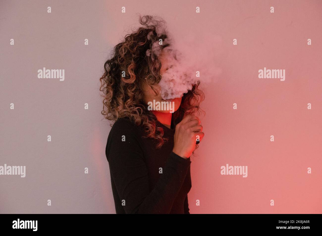 Woman shot indoors smoking a vape Stock Photo - Alamy