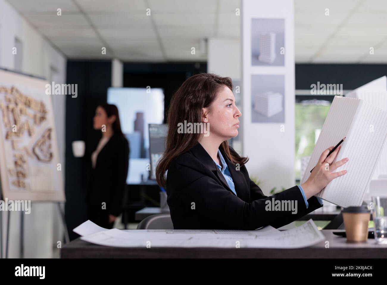 Architecture office employee looking at building 3d printed model ...