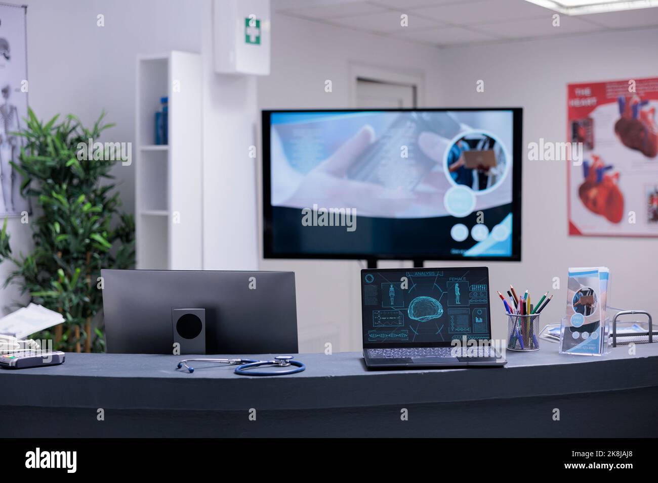 Laptop on medical clinic front desk showing brain scans. Counter with ...