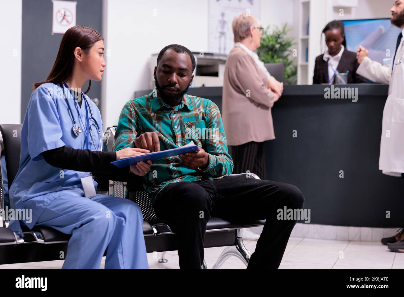 Medical trainee taking personal data from african american patient ...