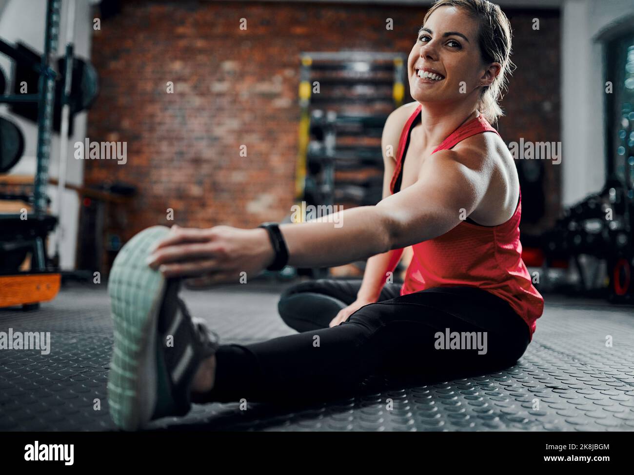 The warmup is all-important. Full length shot of an attractive young female athlete stretching ...