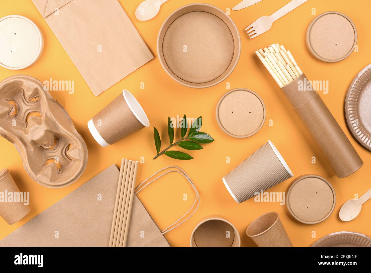 Eco-friendly tableware - kraft paper food packaging over orange ...
