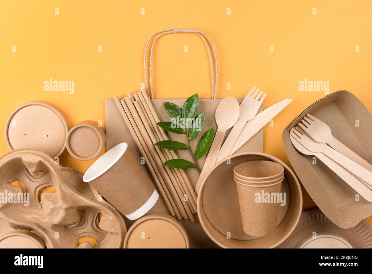 Eco-friendly tableware bundle over orange background - sustainable ...