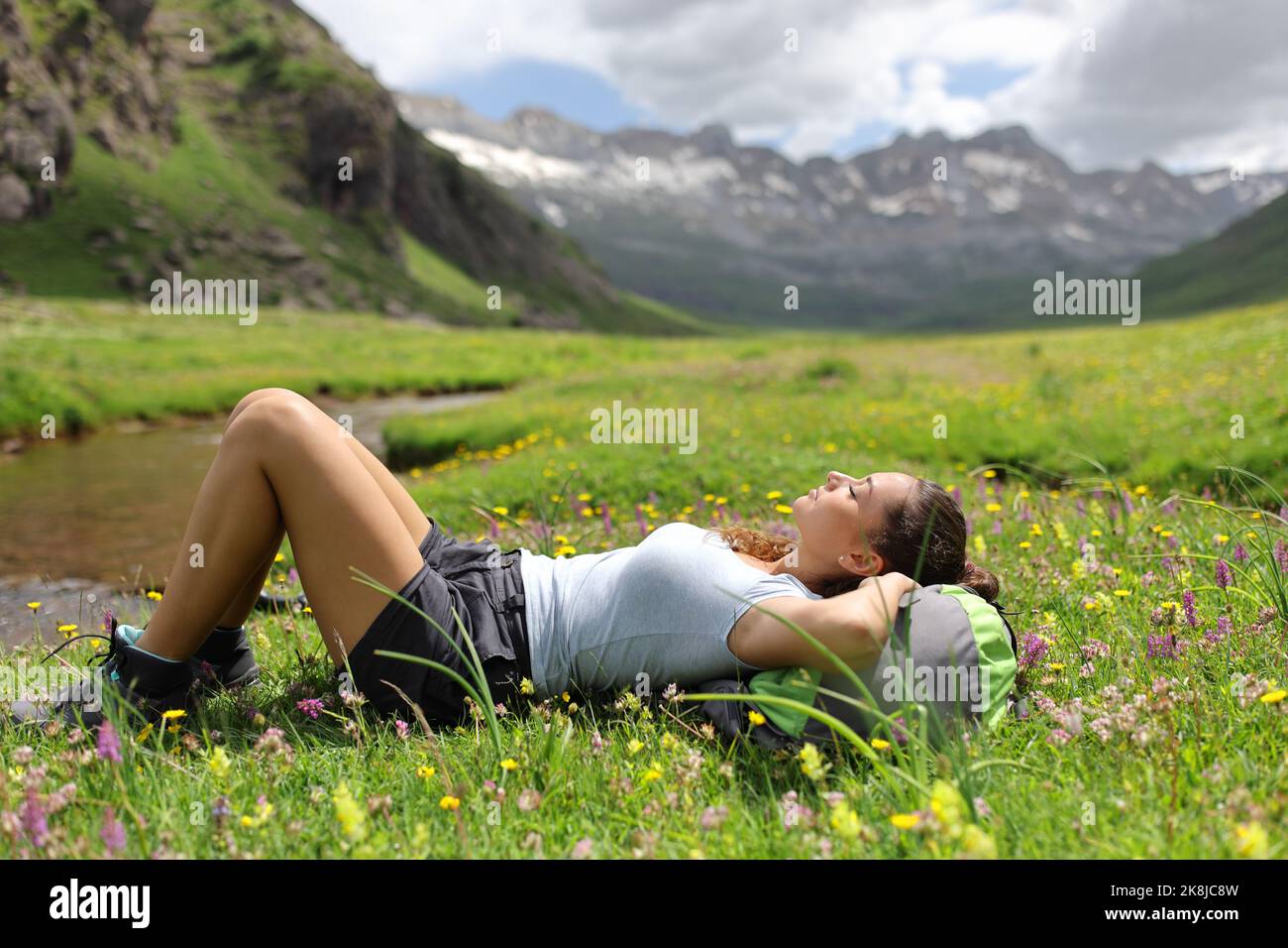 full body side view portrait of a hiker resting in the mountain on ...