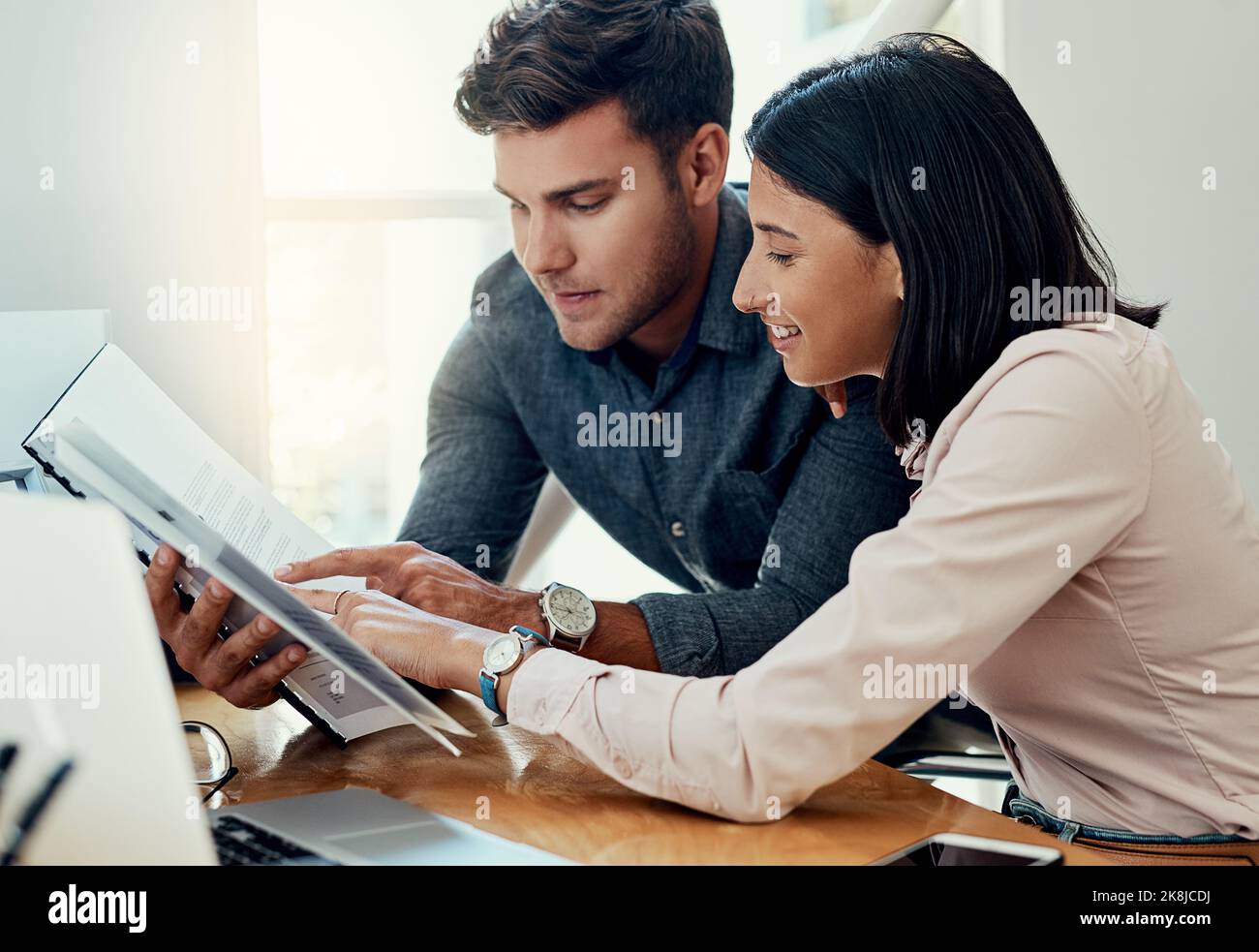 Could you help me out quickly. two young businesspeople sitting ...