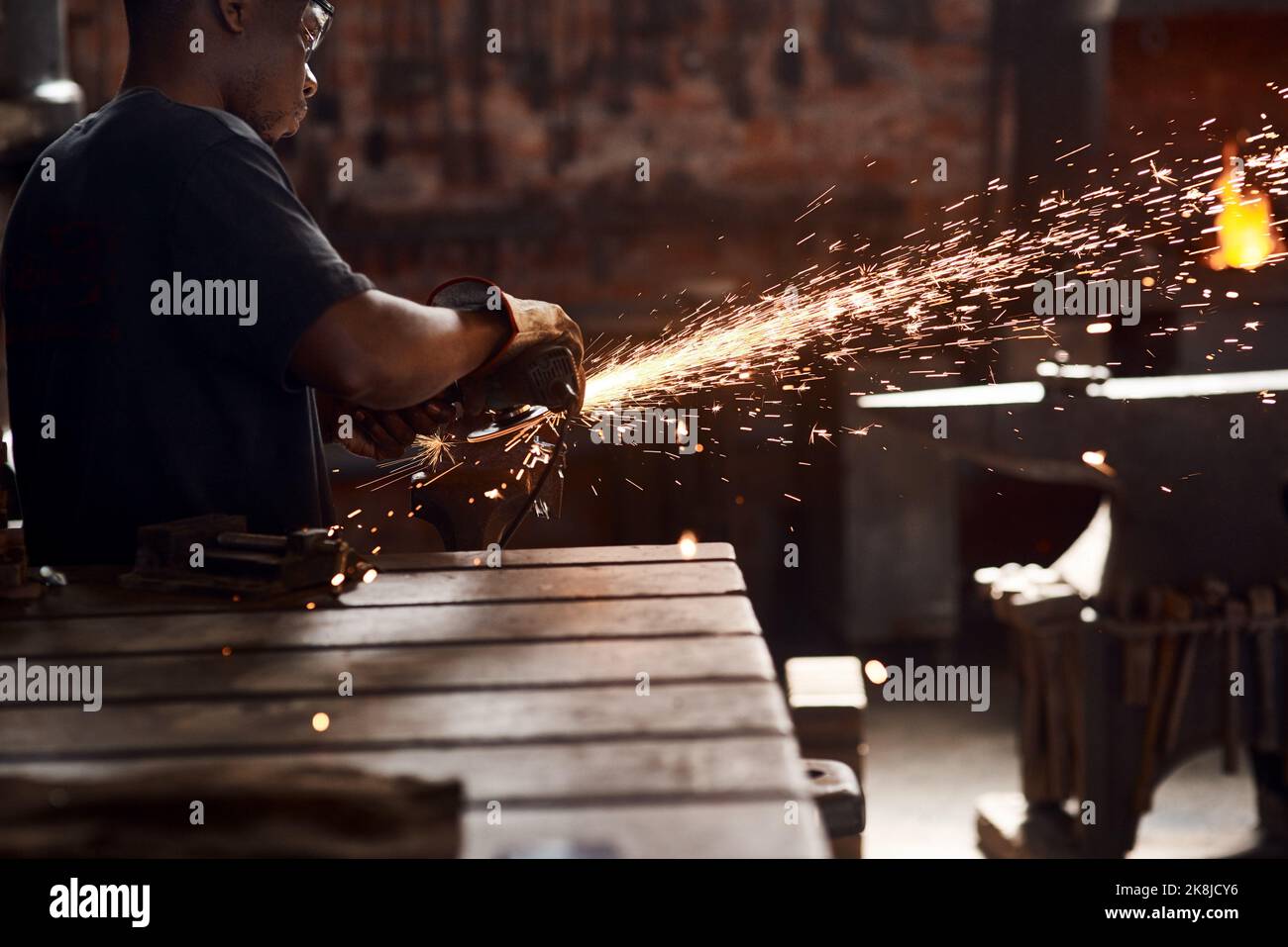 Let the sparks fly. a handsome young metal worker using a blowtorch ...