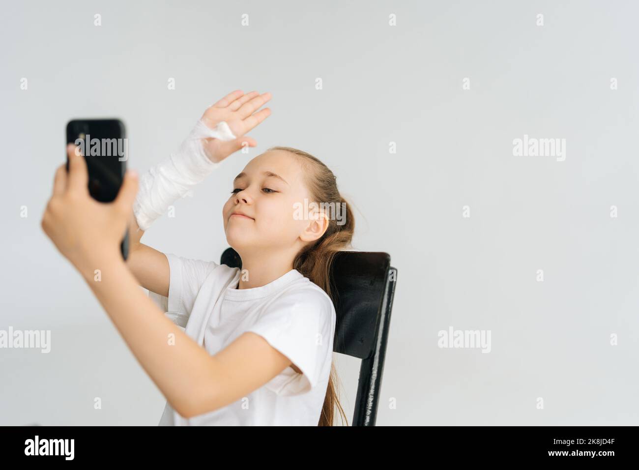 Positive blonde little girl with broken arm wrapped in white plaster ...