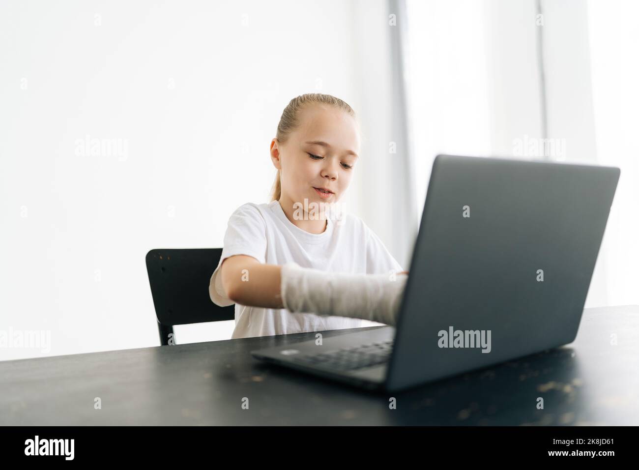 Portrait of cute little girl with broken hand wrapped in white plaster ...