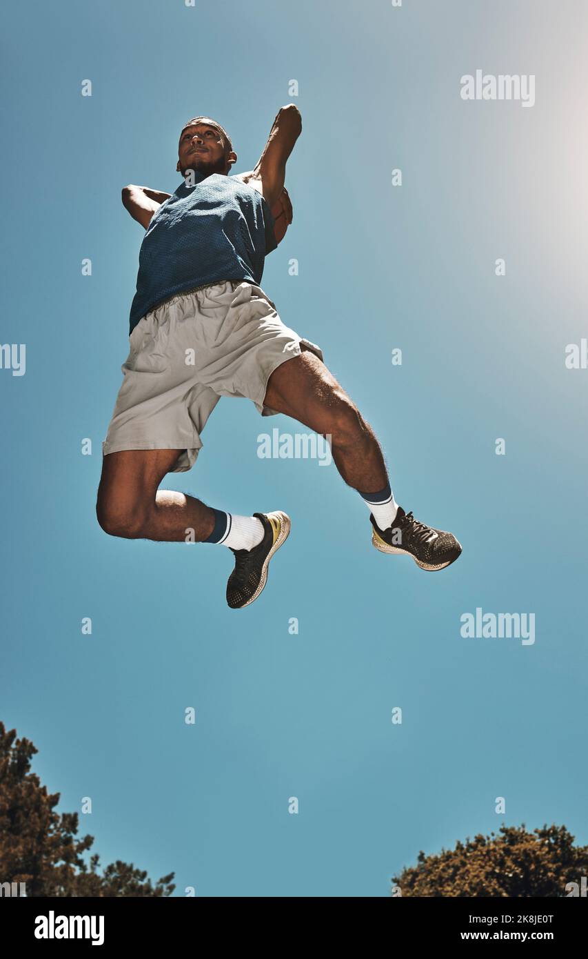 Sports, blue sky and basketball man jump for game, competition or slam ...