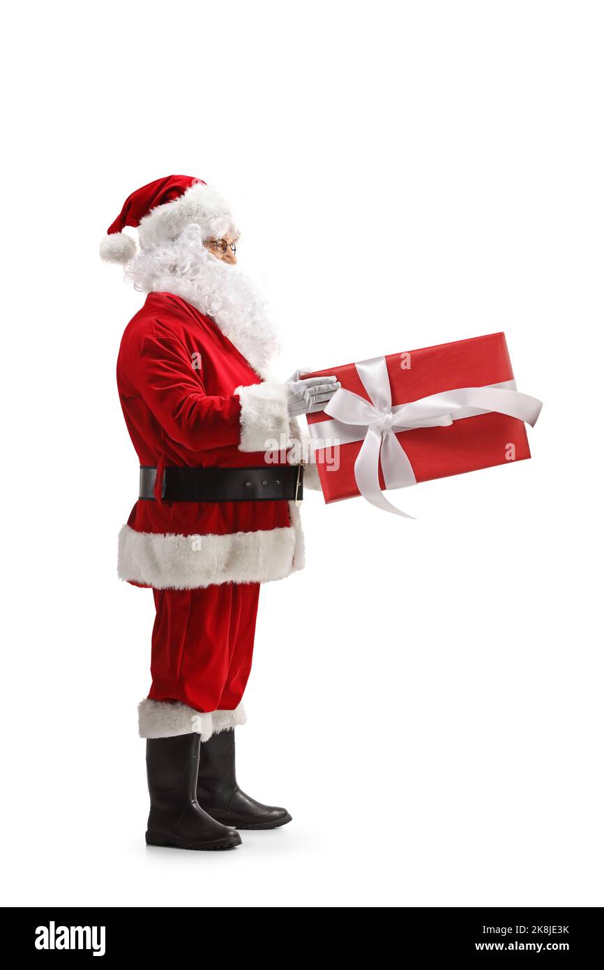 Full length profile shot of santa claus holding a big present isolated ...