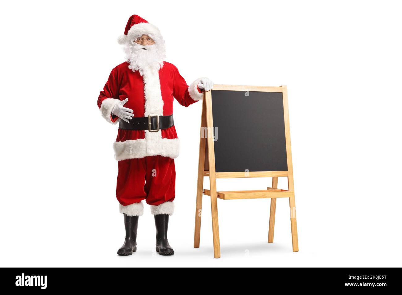 Santa claus standing next to a small school blackboard with a wooden ...