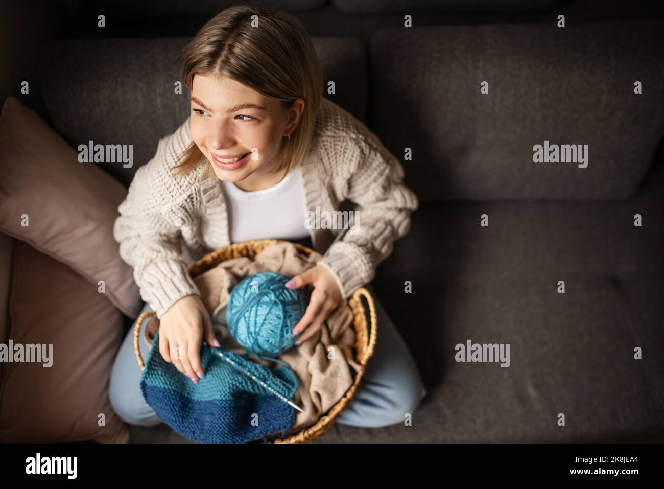 Adult attractive woman at home in knitting work activity using colorful ...