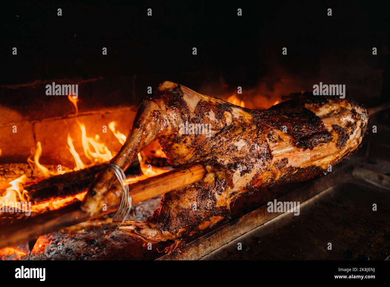 The lamb is cooked entirely on a spit on the fire. Cooking Stock Photo ...