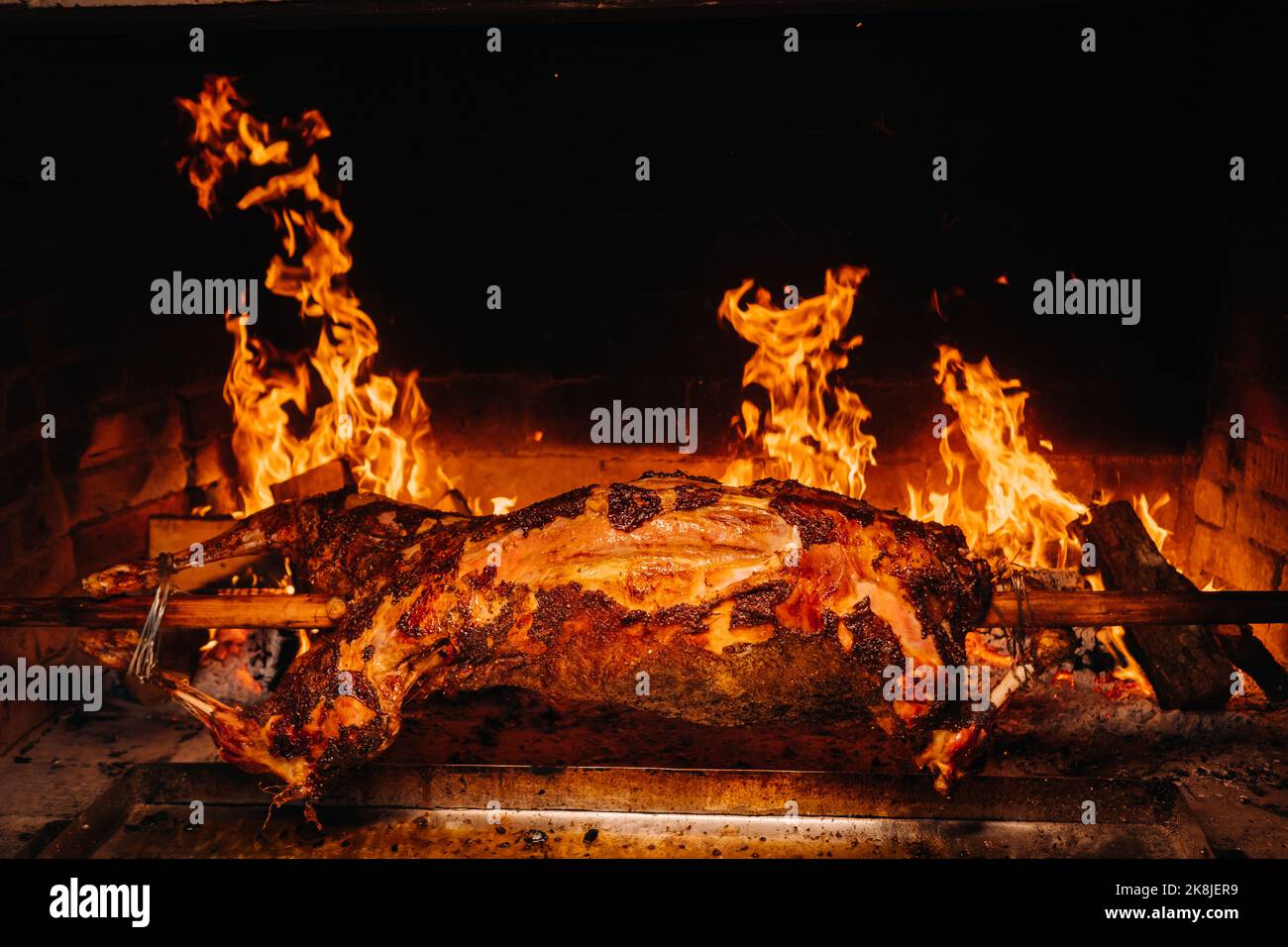 The lamb is cooked entirely on a spit on the fire. Cooking Stock Photo ...