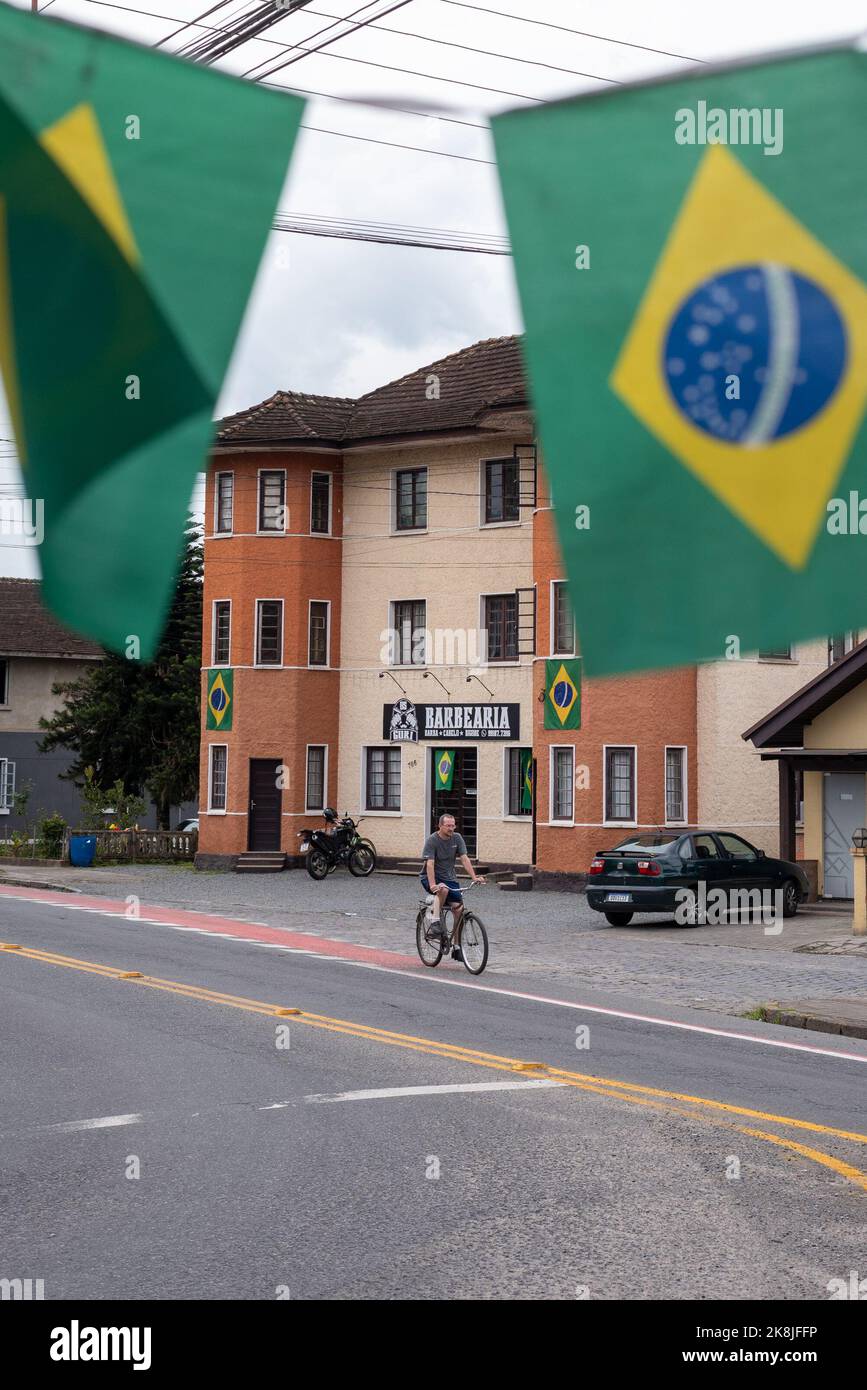 Pomerode, Brazil. 27th Sep, 2022. A woman rides her bike past a house ...