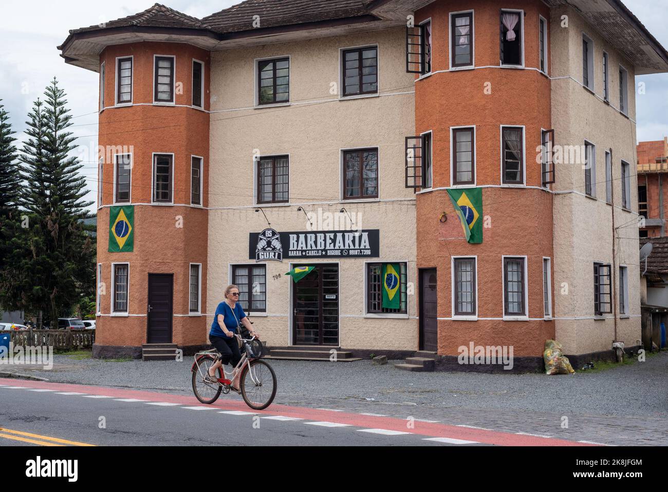 Pomerode, Brazil. 27th Sep, 2022. A woman rides her bike past a house ...