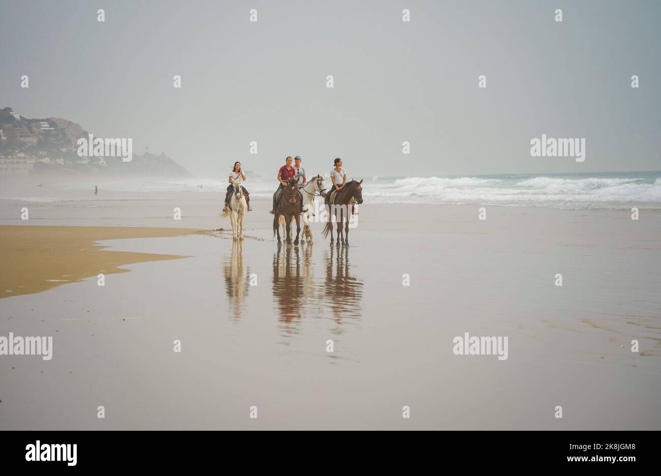 A group of horseback riders at the beach near Tarifa, during sunset ...