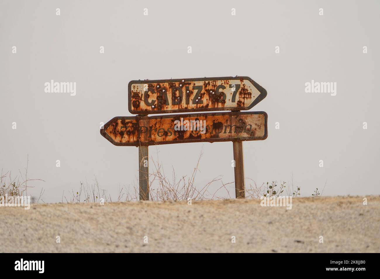 Weathered and rusty directional road sign, to Cadiz, Spain Stock Photo ...