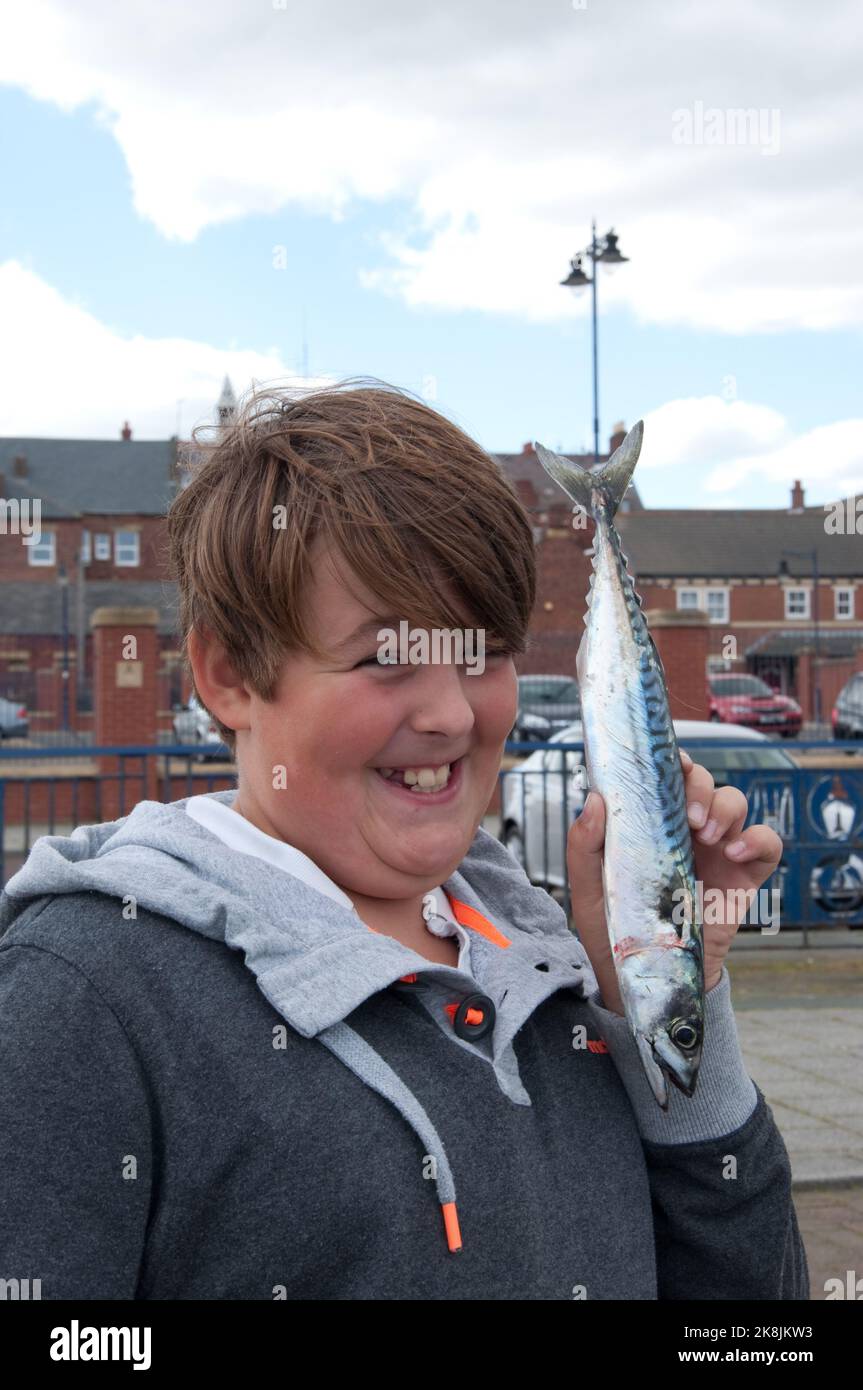 Boy proudly showing a fish he has caught hi-res stock photography and ...