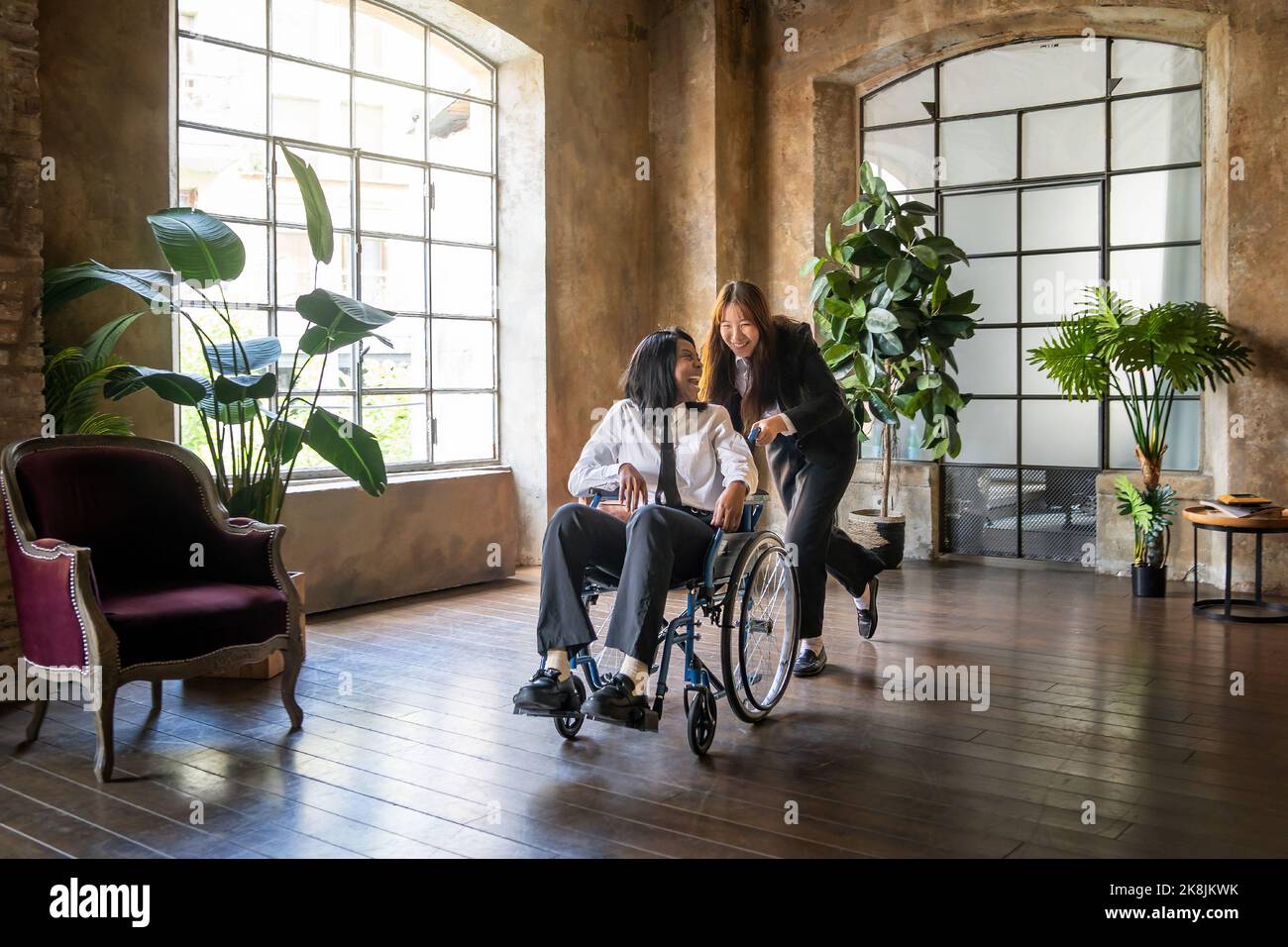 Two best friends and work colleagues, one with a disability, have fun ...