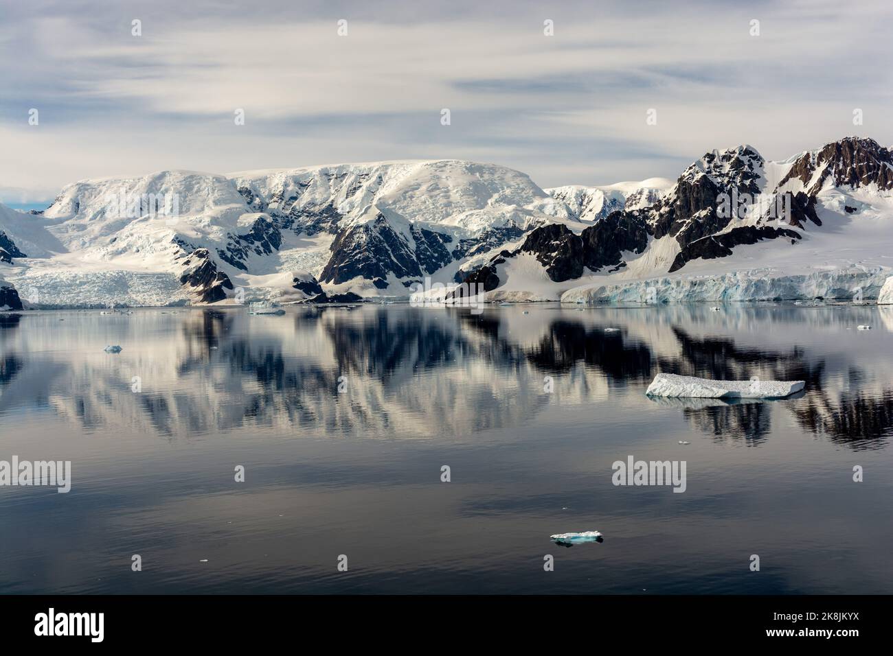 still waters of paradise harbour (bay) with bryde island (r) and peaks ...