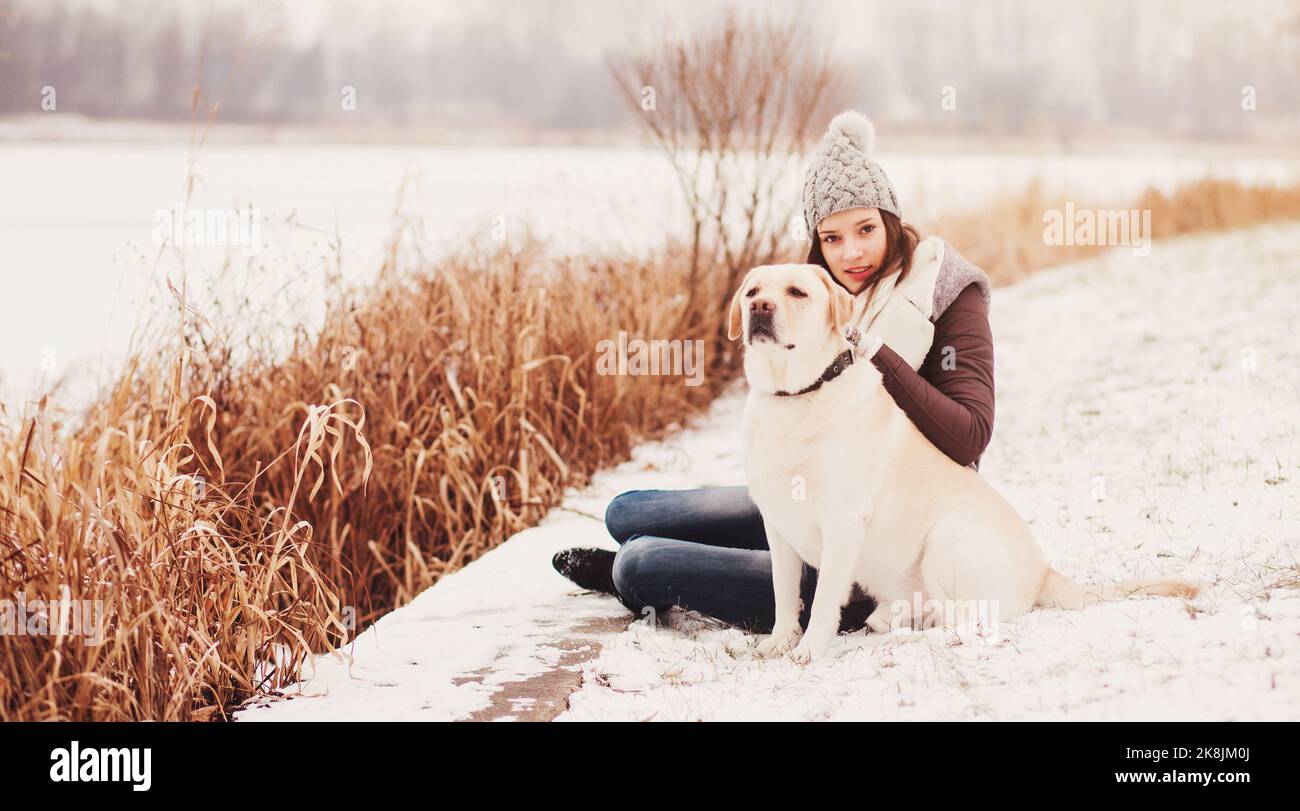 Girl stroking dog in winter park Stock Photo - Alamy