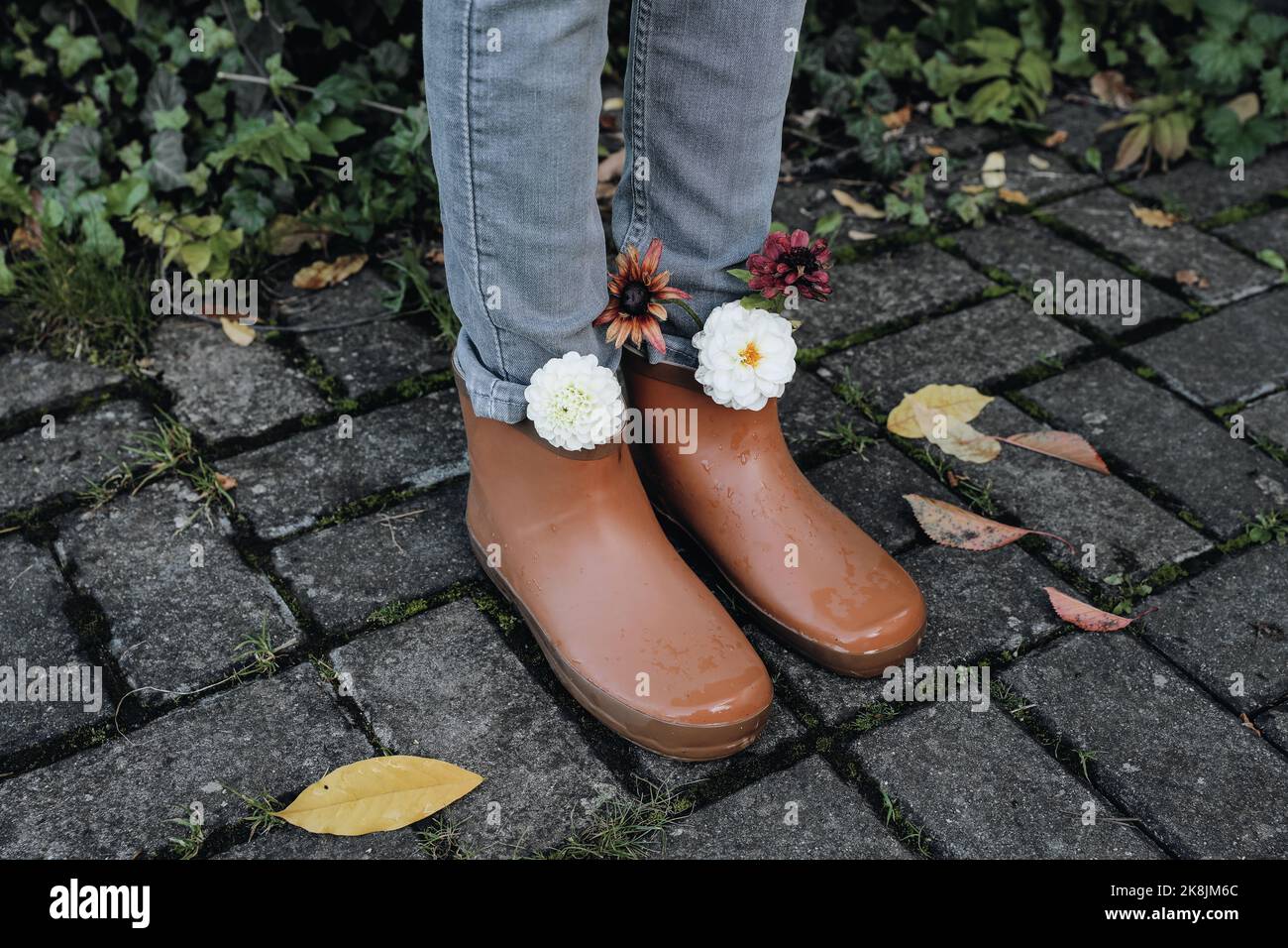 Autumn lifestyle moody photo. Rusty rubber boots with floral bouquet in ...