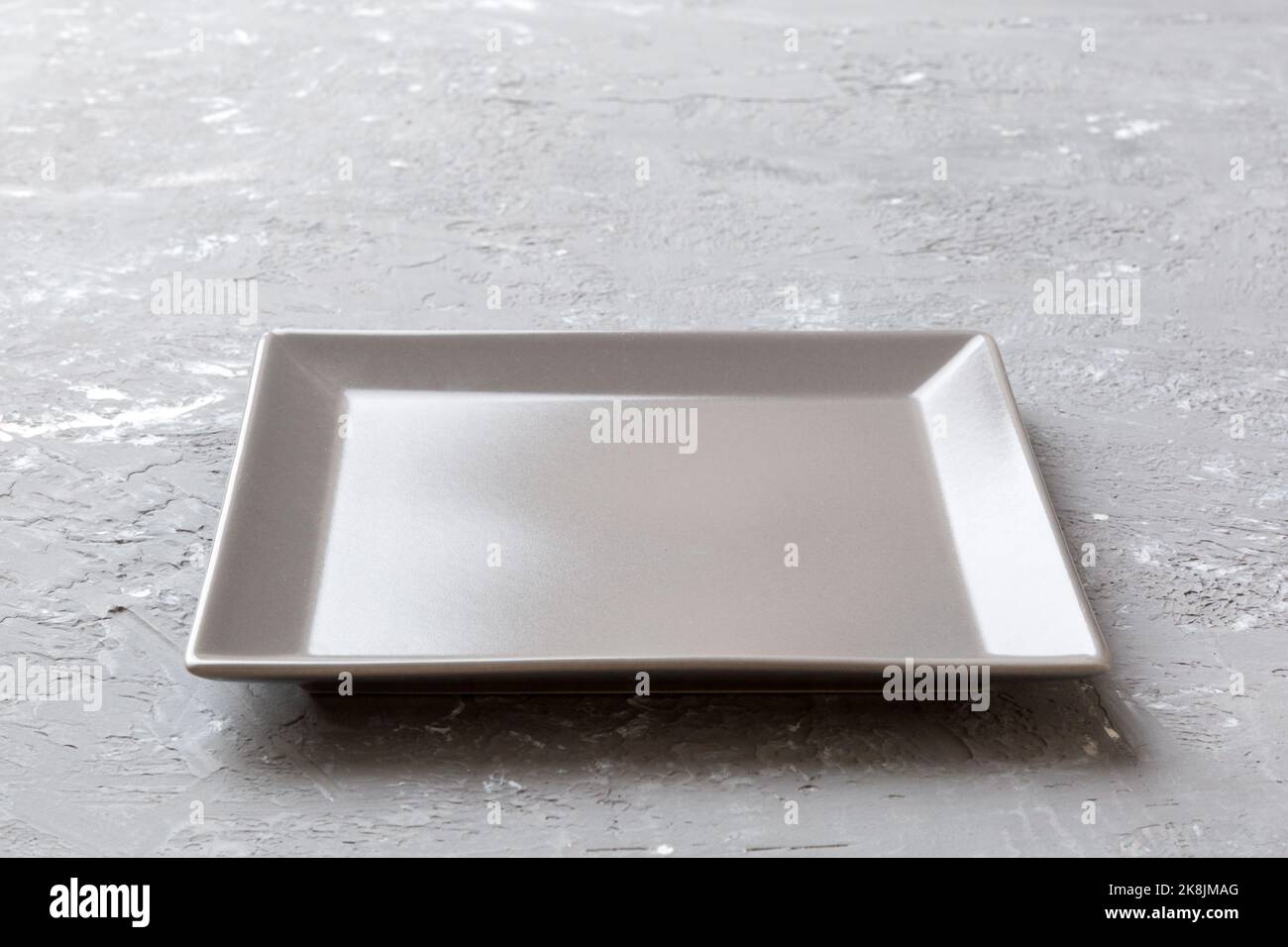 Perspective view of empty square plate on cement background. Empty ...