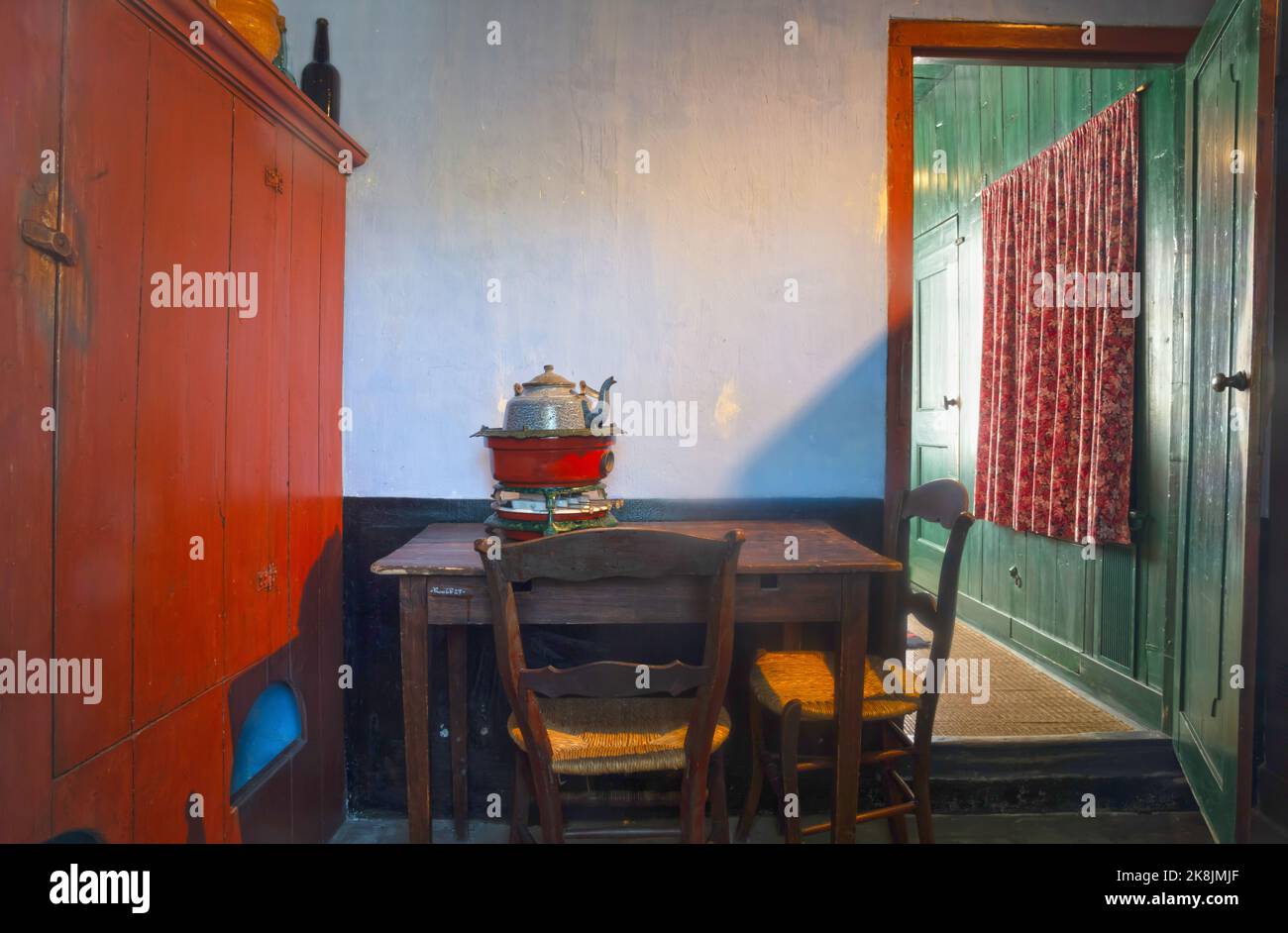 Old antique metallic red kettle with auto-heating in a vintage dutch ...