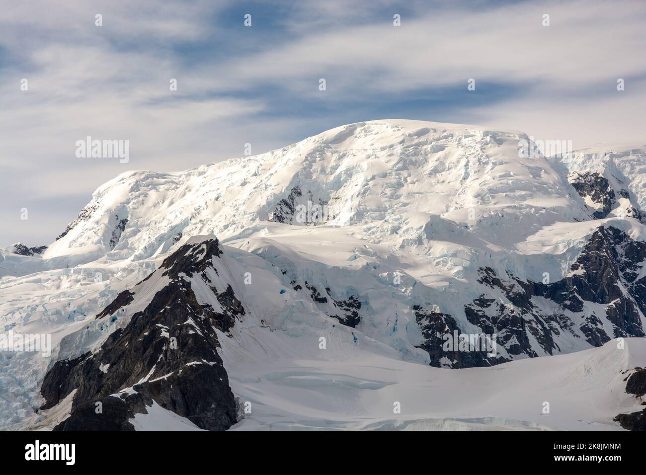 snow covered peaks of danco coast behind brown base. paradise harbour ...