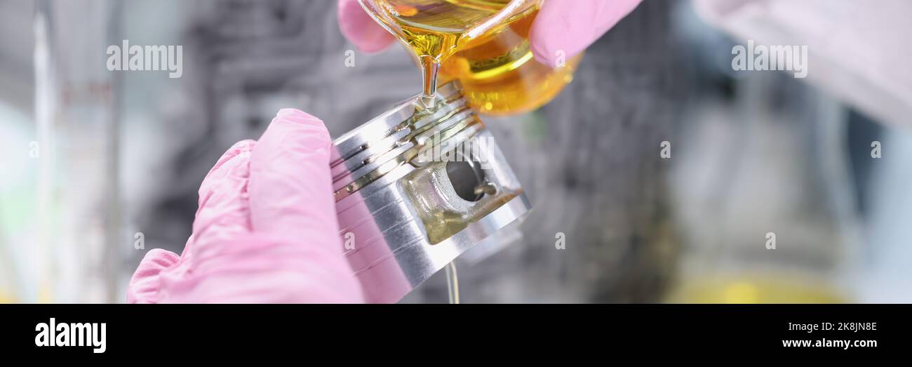 Person hand in rubber pink gloves holding car part and pours ...