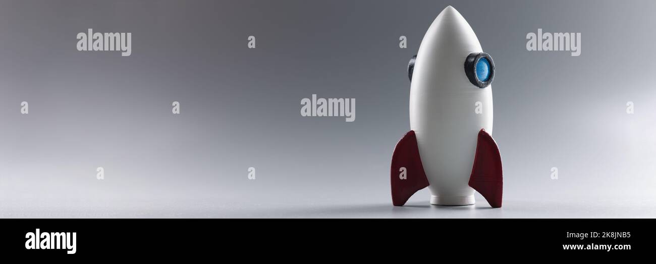 Rocket toy model stand on grey surface, rocketship as symbol for ...