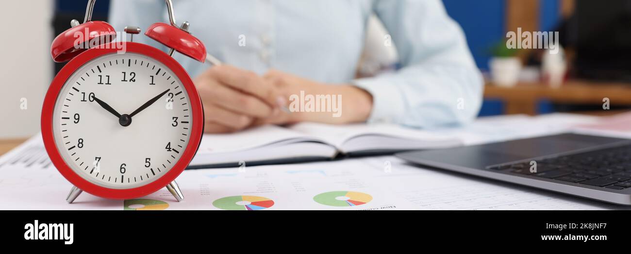 Woman at work, clock set on ten oclock in morning, work in progress ...