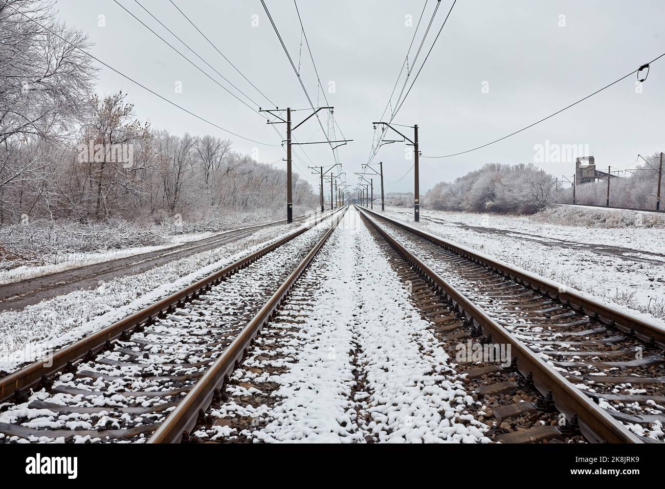 Train tracks in winter with frost covering around everywhere and power ...