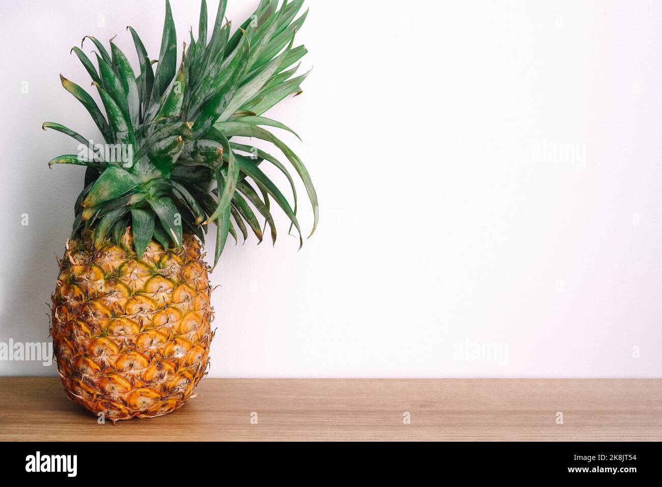 pineapple on a wooden table against white background Stock Photo - Alamy
