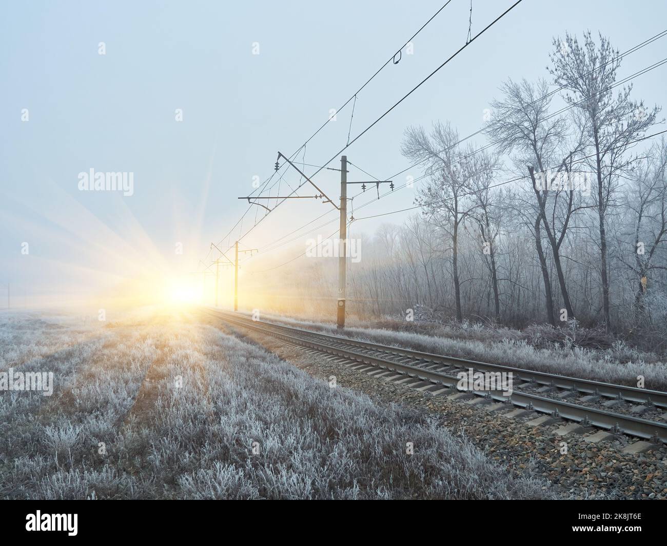 Train tracks in winter with frost covering around everywhere and power ...