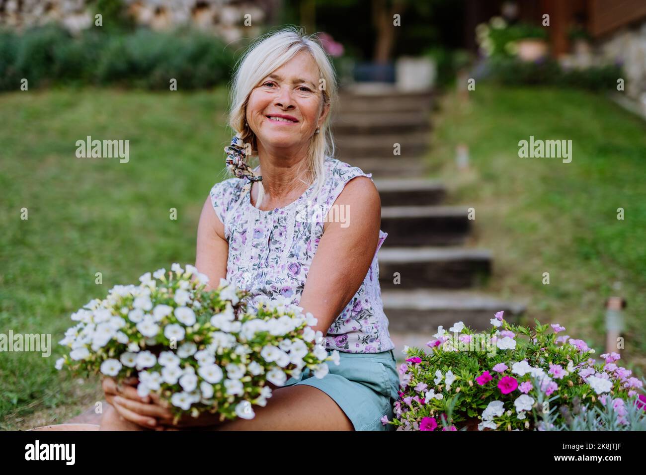 Senior woman in garden at home with her flowers Stock Photo - Alamy