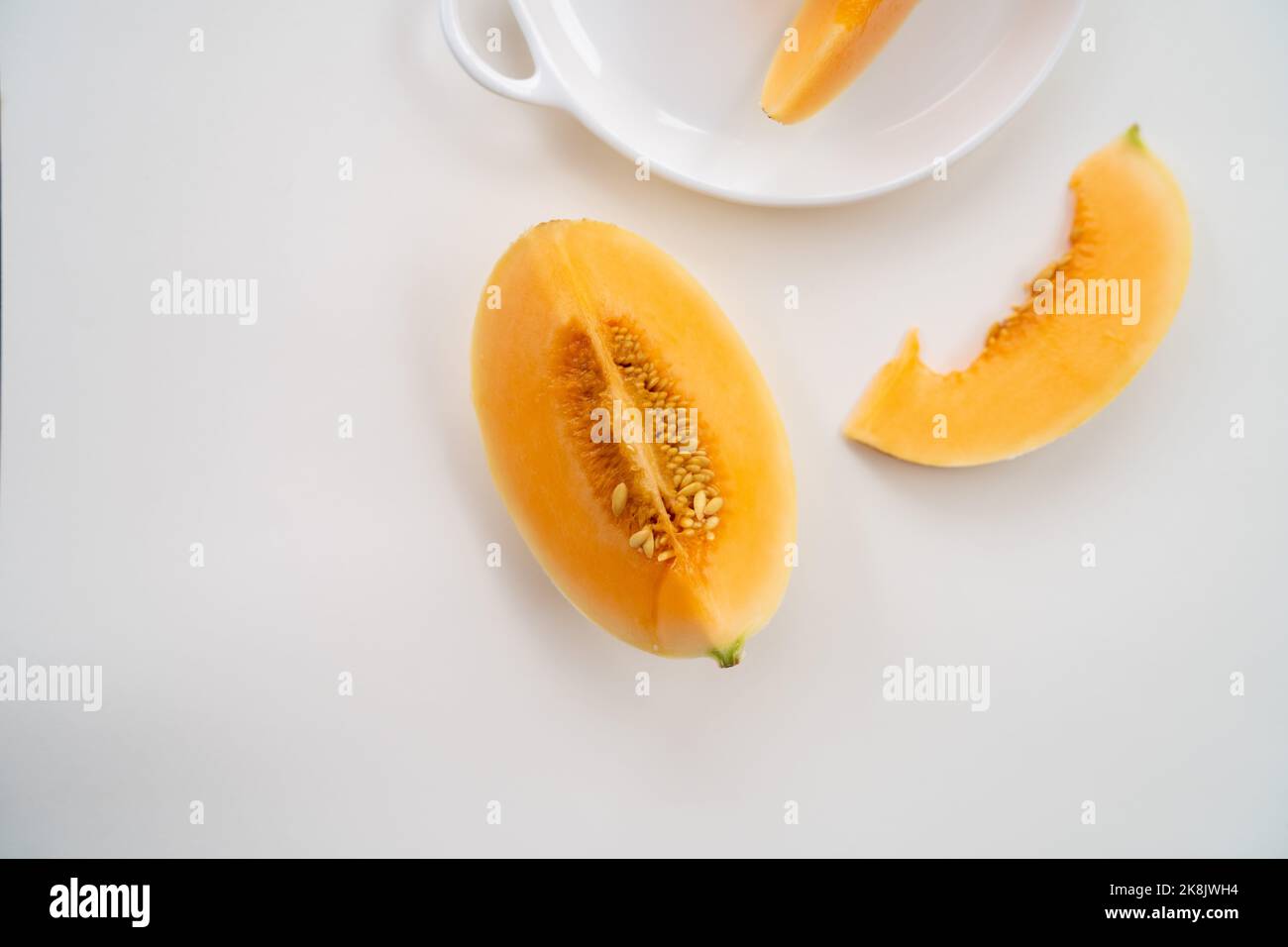 A top view of sweet fresh melon slices on a plate isolated on a white ...