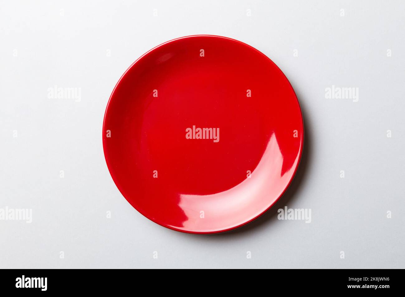 Top view of isolated of colored background empty round red plate for ...