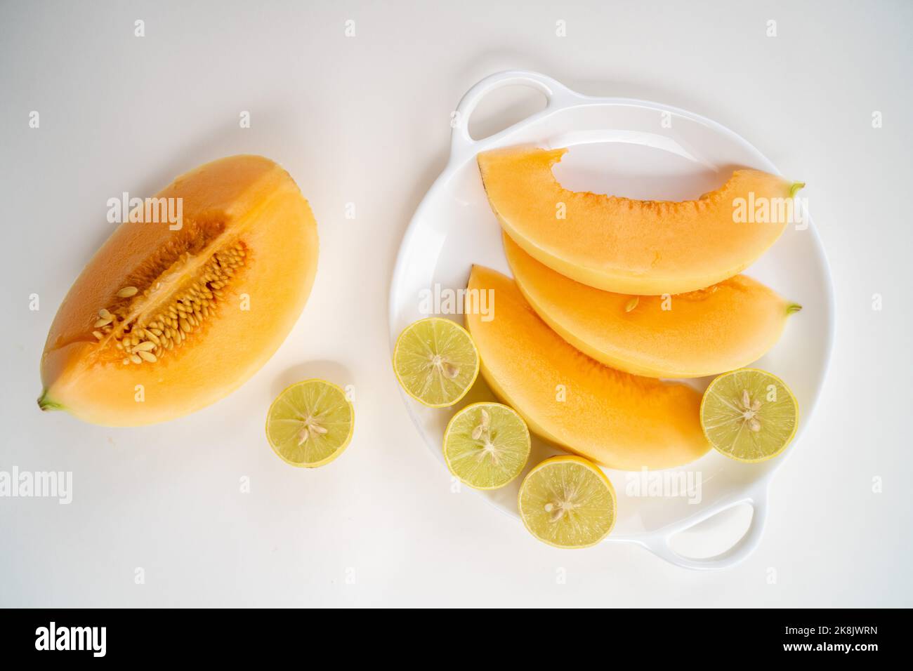 A top view of sweet fresh melon and lemon slices on a plate isolated on ...