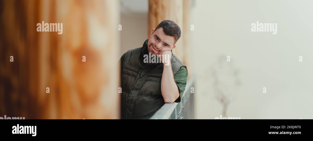 Portrait of young pensive man with down syndrome, resting after ... Portrait of young pensive man with down syndrome, resting after ...