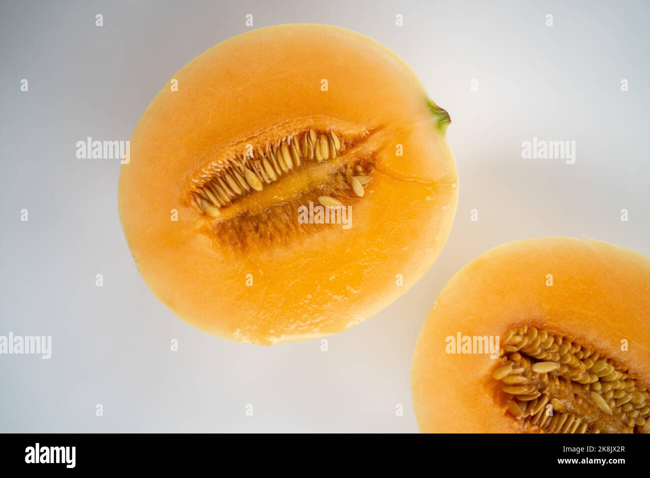 A top view of sweet fresh melon halves isolated on a white background ...