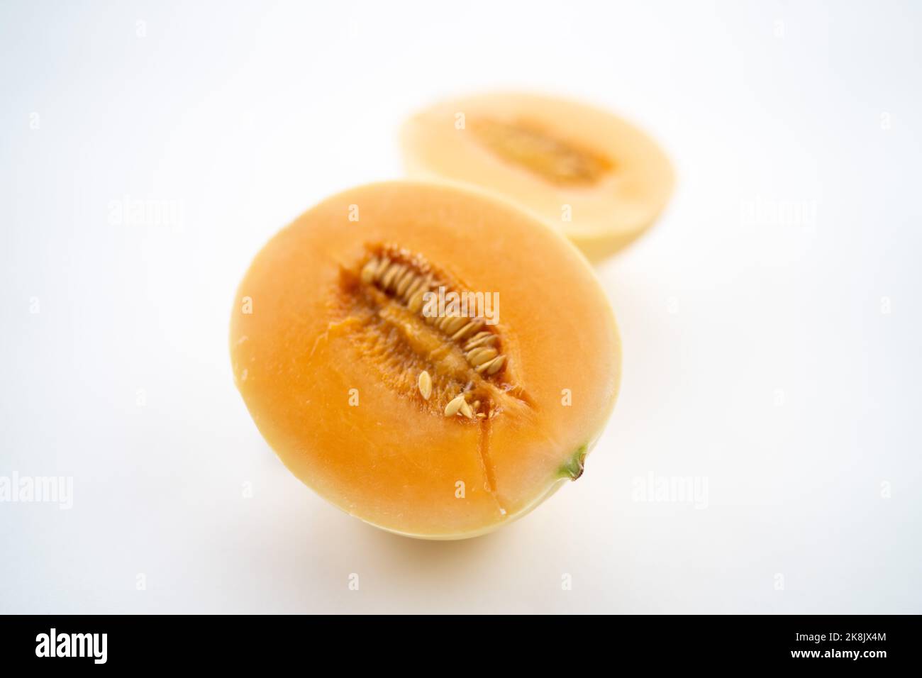 A closeup of sweet fresh melon halves isolated on a white background ...