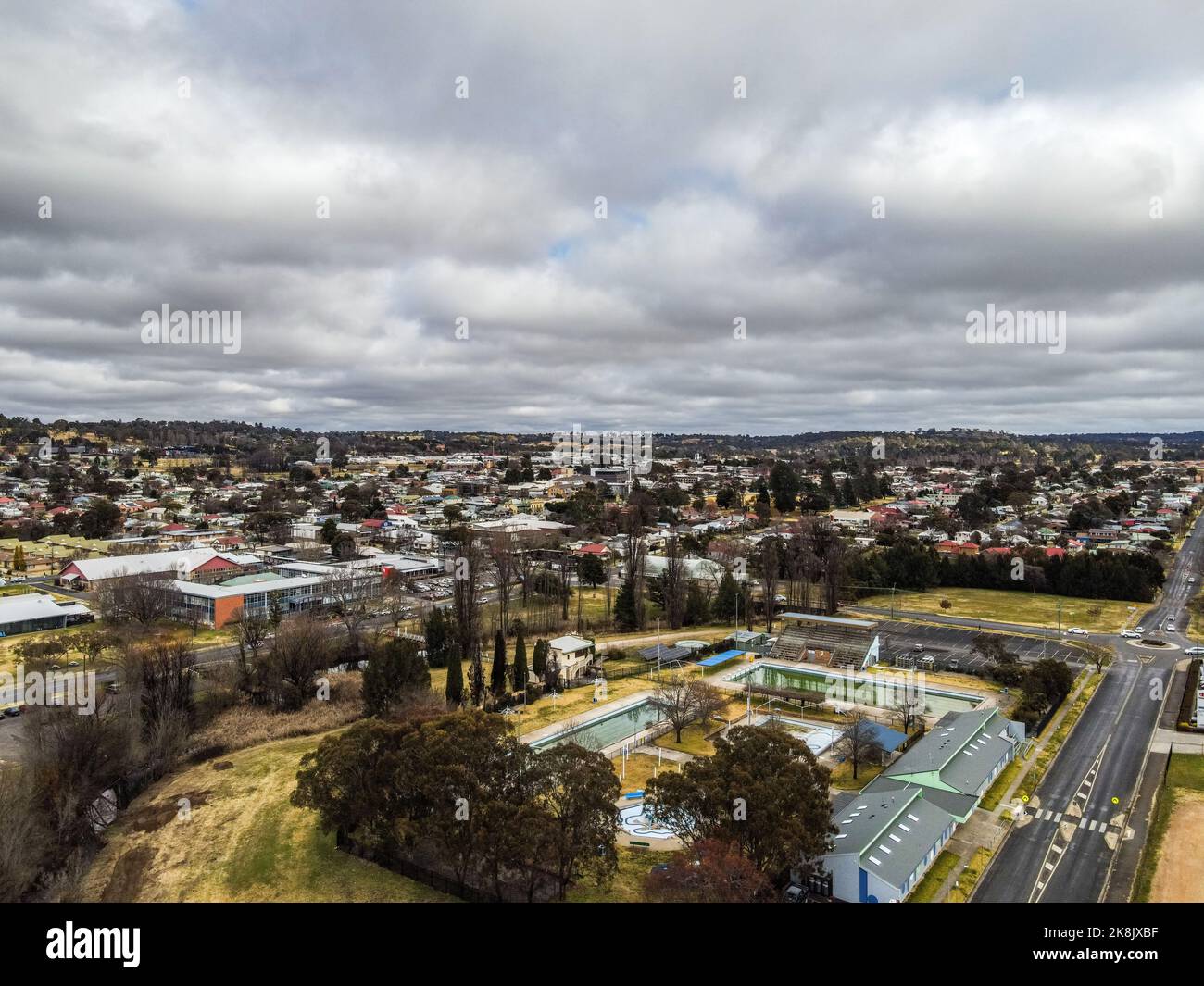 An aerial shot of country town buildings, main street, dry trees, and ...