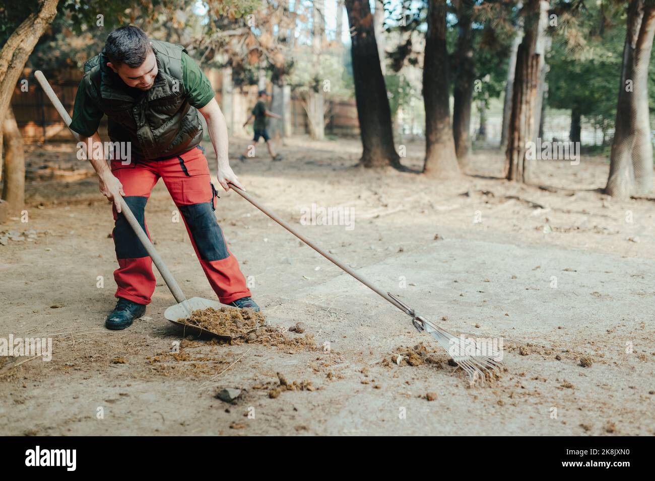 Caretaker with down syndrome in zoo cleaning animal enclosure. Concept ...