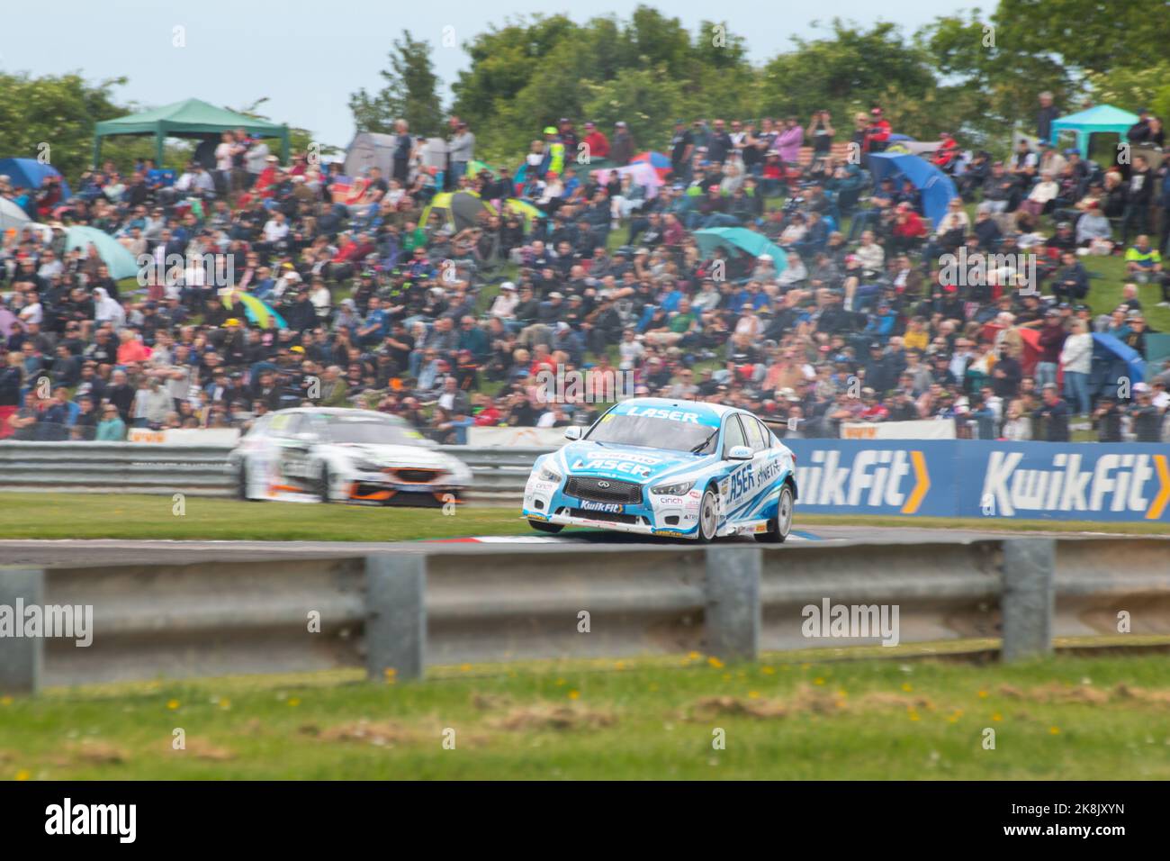 A British Touring Car on the track at Thruxton with blurred background ...