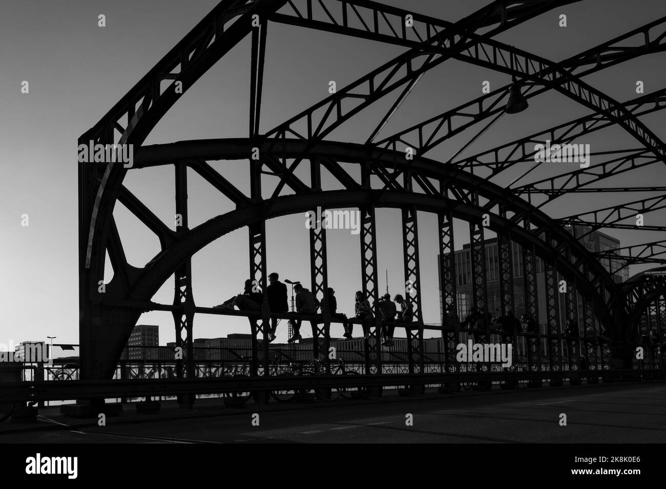 A grayscale of people on the bridge enjoying the sunset Stock Photo - Alamy