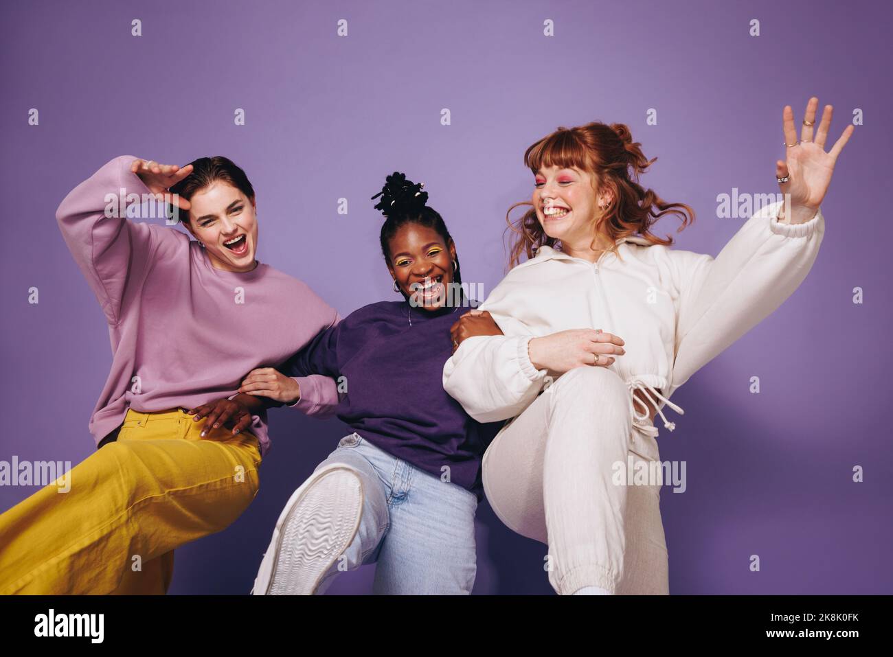 Energetic female friends dancing and having fun in casual clothing ...